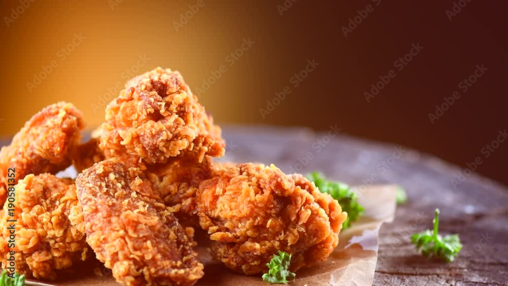 Bucket full of crispy fried chicken rotated on wooden background. 4K ...