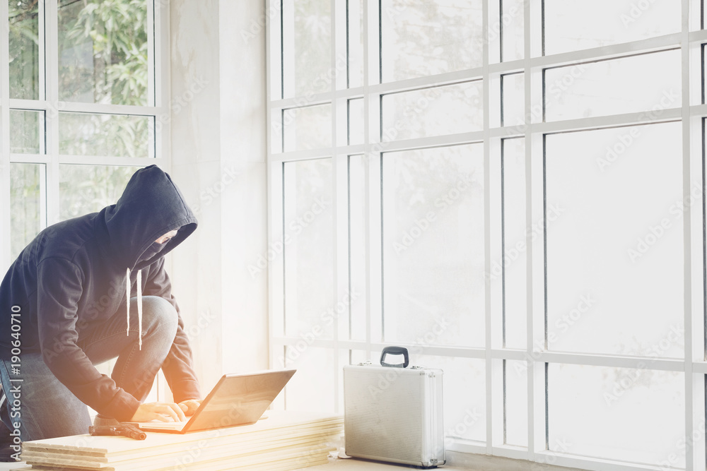 Hacker holding gun working on his computer, war, terrorism , terrorist ...