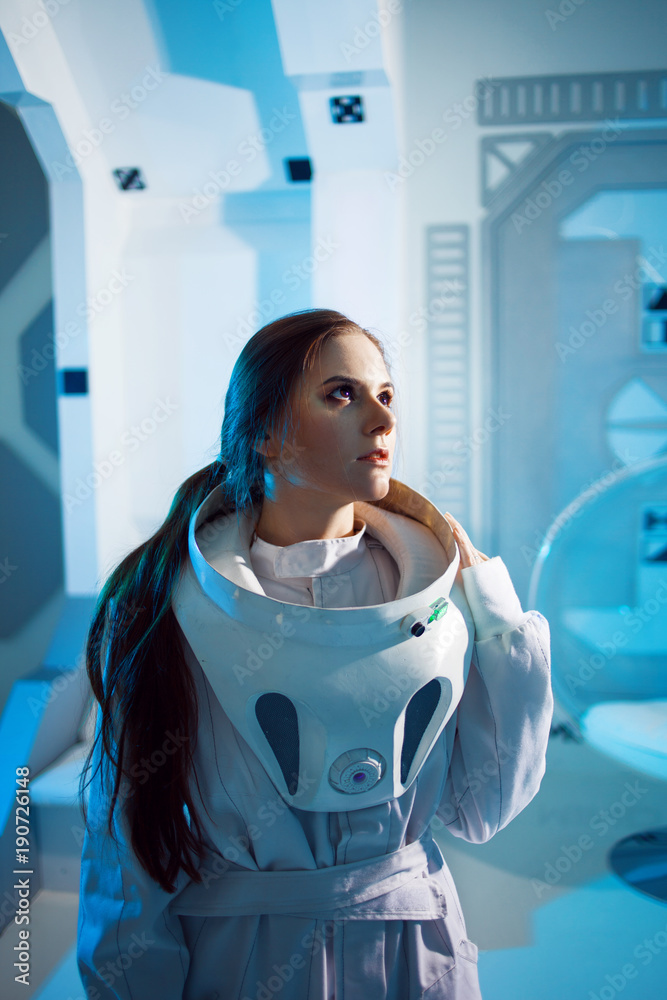 Portrait of a woman astronaut in a space suit, dreamy look up ...