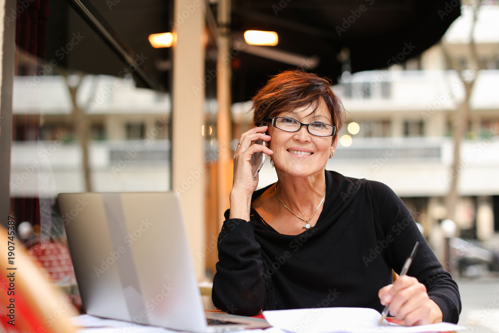 Female accountant sitting at outdoor cafe with laptop and making ...