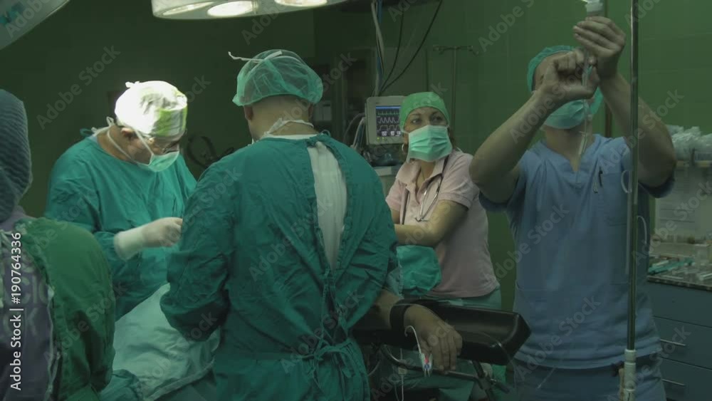 Anesthetist using syringe to injecting fluids in intravenous drip ...