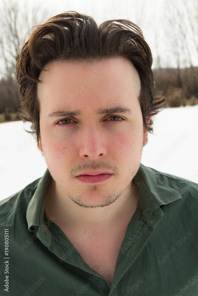 Retrato de Hombre Joven mirando a camara y fondo de paisaje nevado ...