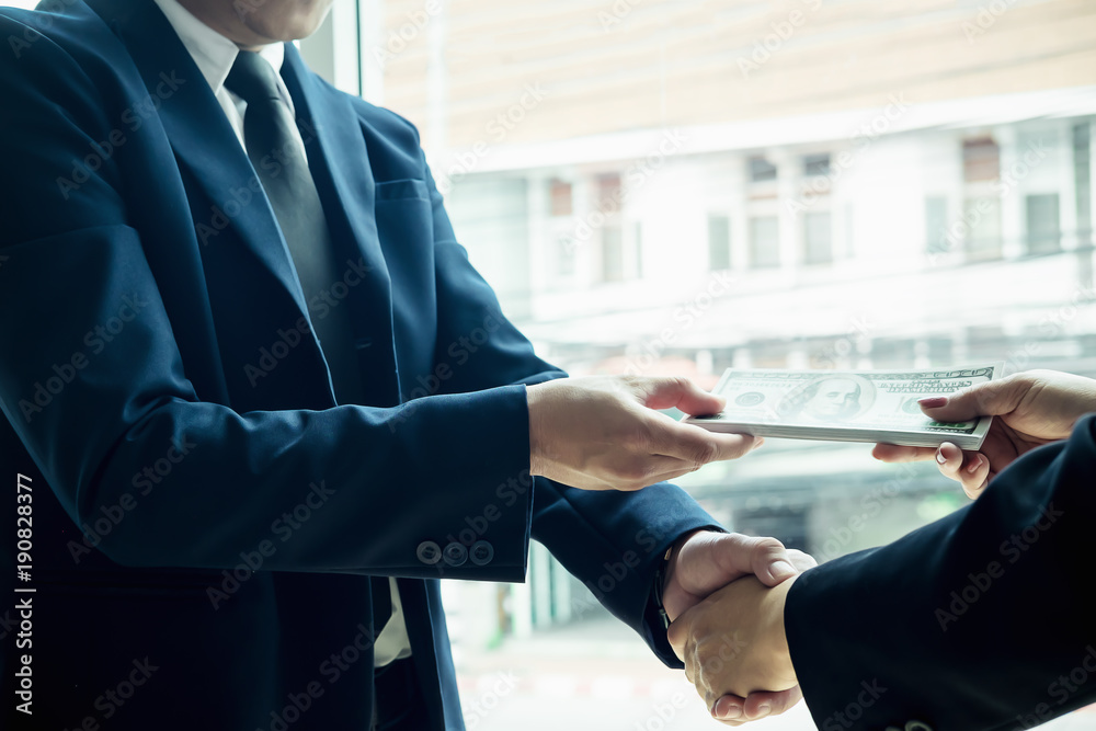 Business man sealing the deal with handshake and receiving a bribe ...