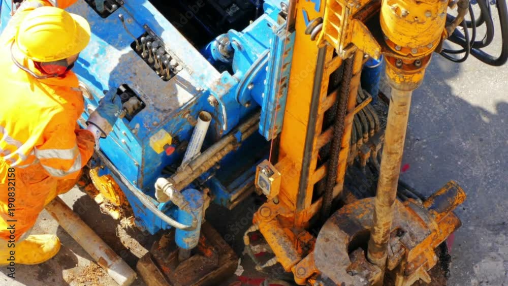 Drilling rig worker dressed in yellow helmet and working clothes ...