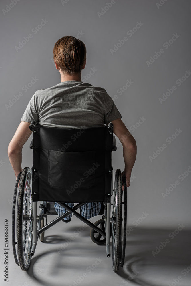 Back of guy with physical inability sitting in wheelchair. He is ...