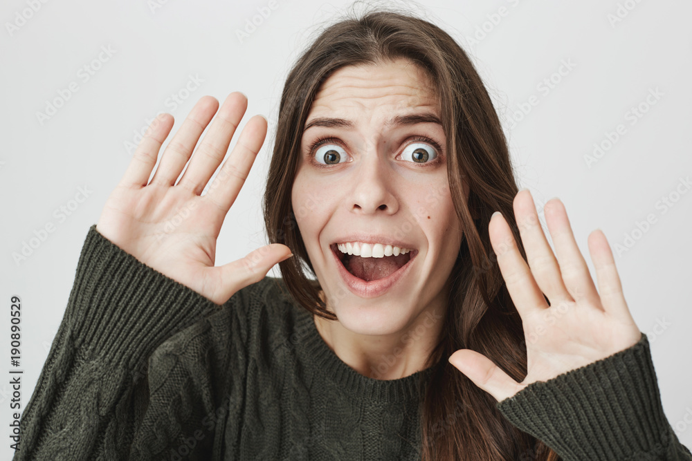 Excited young female with dark hair exclaiming, looking at camera in ...
