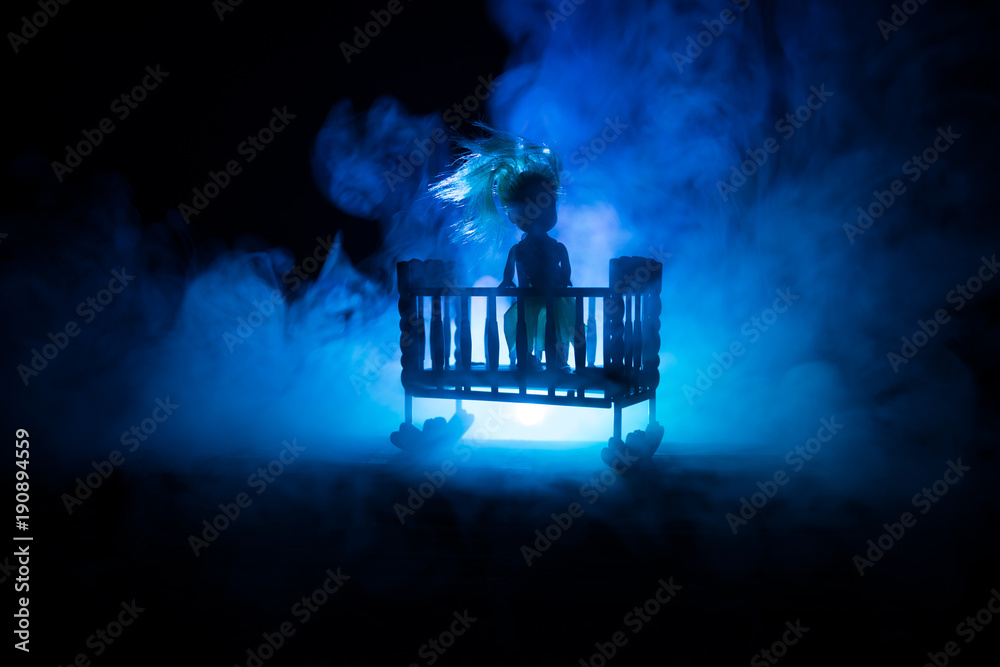Old creepy eerie wooden baby crib in dark toned foggy background ...