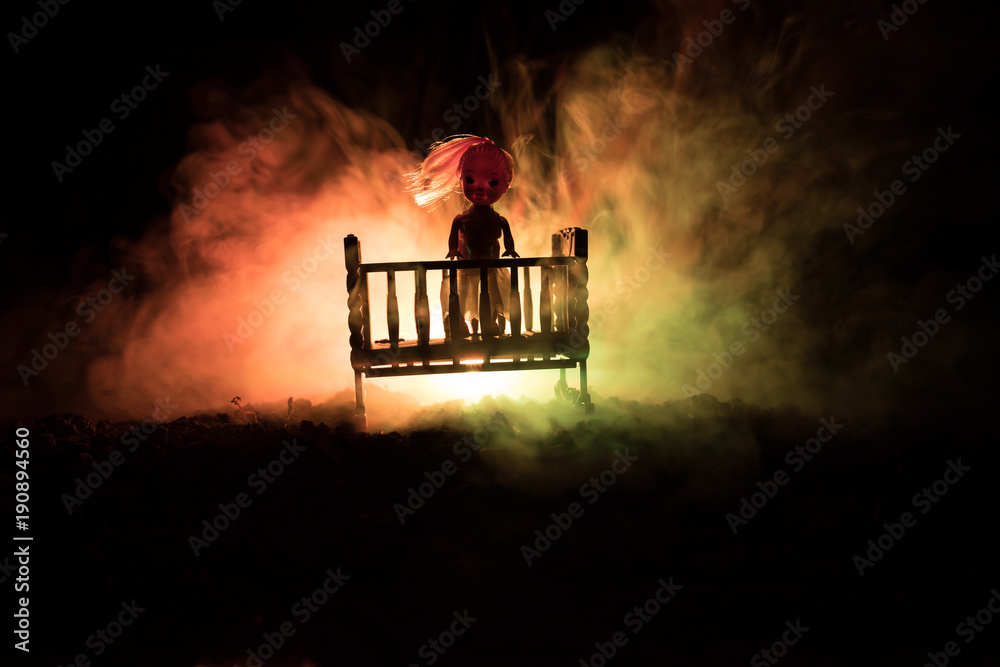 Old creepy eerie wooden baby crib in dark toned foggy background ...