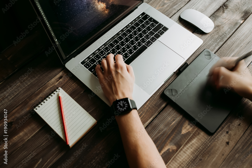 Foto de Man designer is working using laptop computer and graphics ...