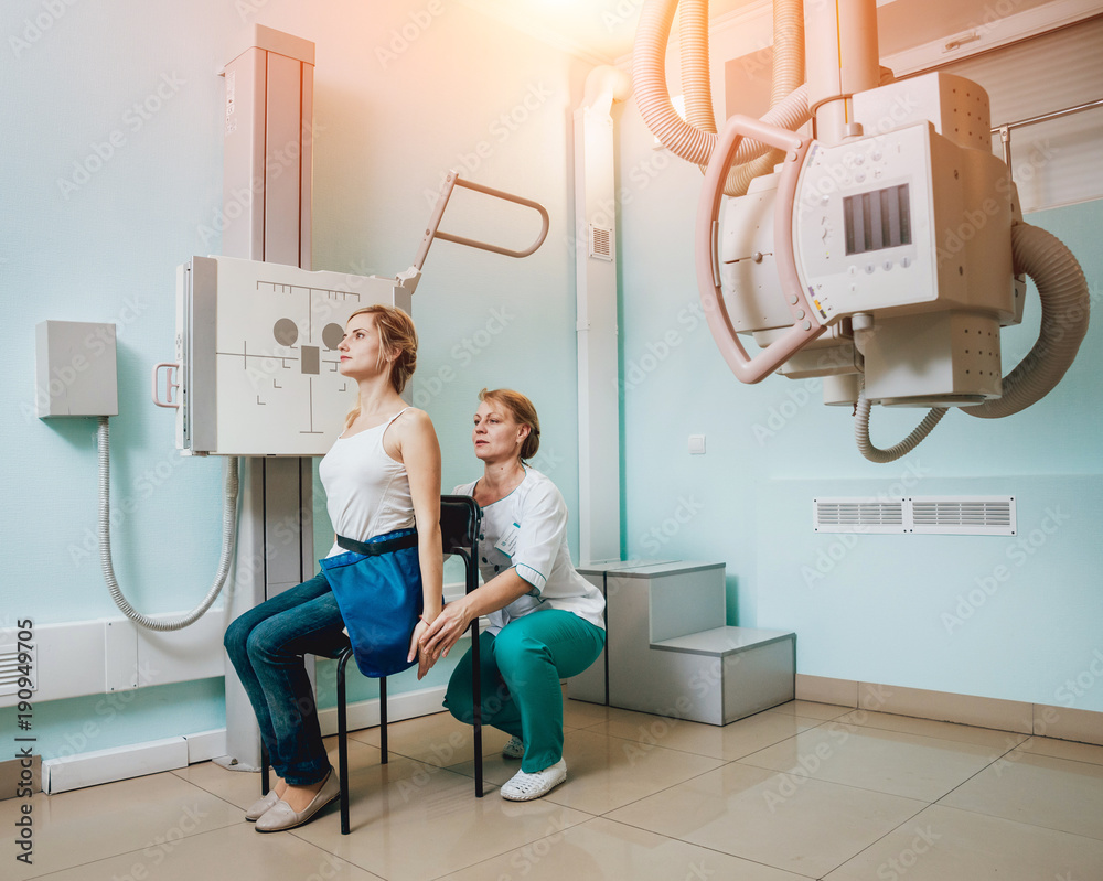 Radiologist and patient in a x-ray room. Classic ceiling-mounted x-ray ...