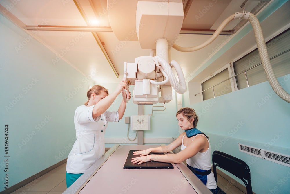 Radiologist and patient in a x-ray room. Classic ceiling-mounted x-ray ...