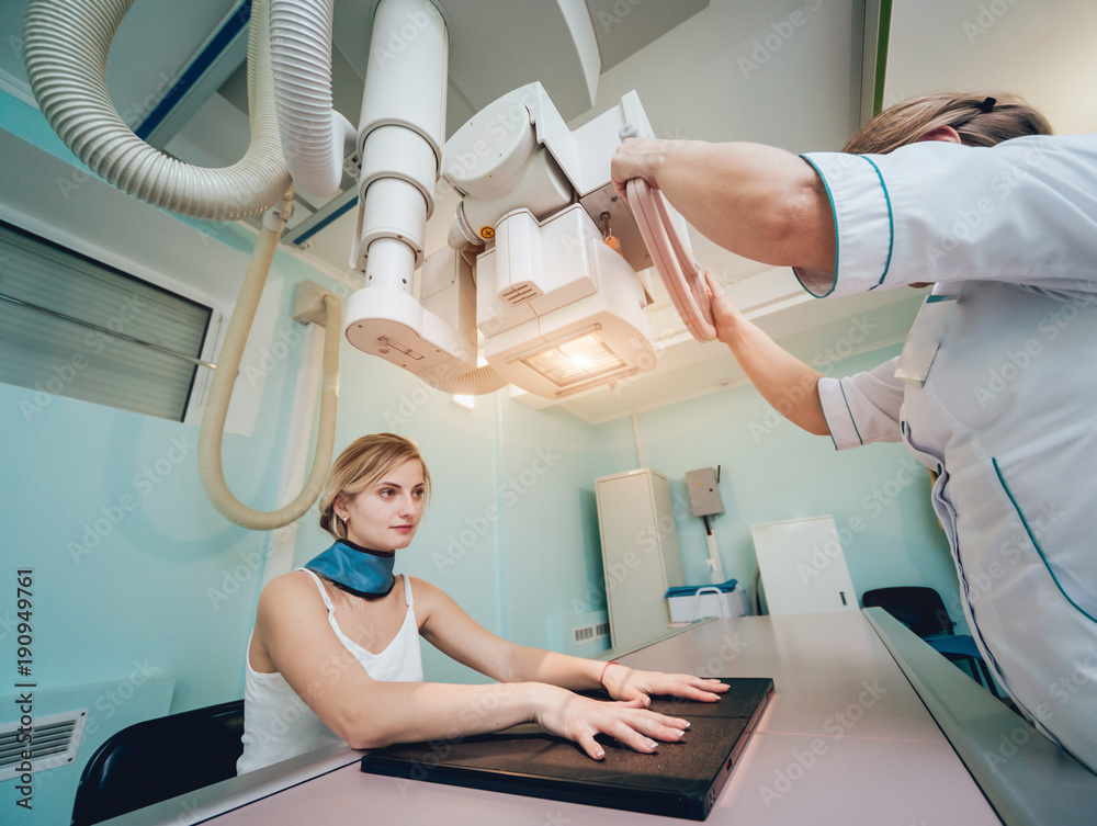Radiologist and patient in a x-ray room. Classic ceiling-mounted x-ray ...