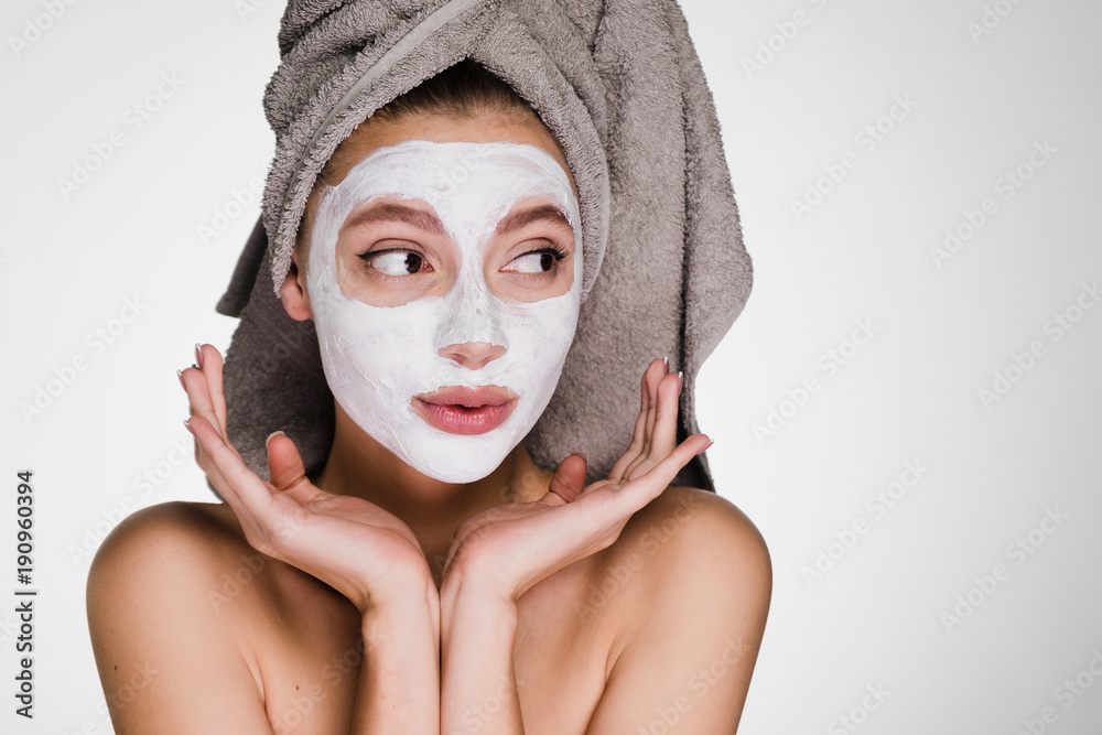 woman with a towel on her head after shower applied a mask to clean the ...