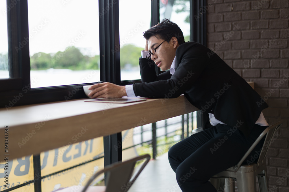 Tired businessman sleeping on counter bar at coffee shop with document ...
