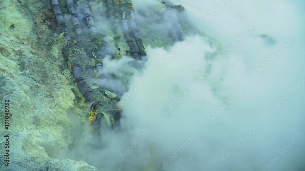 Extraction of sulfur in the crater of a volcano. Sulfur gas, smoke ...