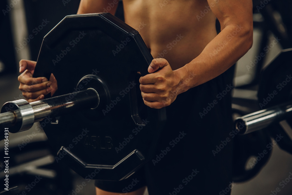 Male hand choosing a weight on a metal weights of bodybuilding ...