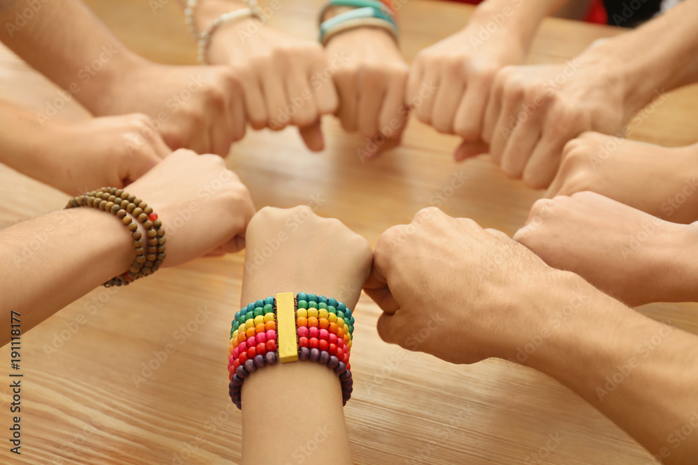 Group of people putting hands together over wooden table as symbol of ...