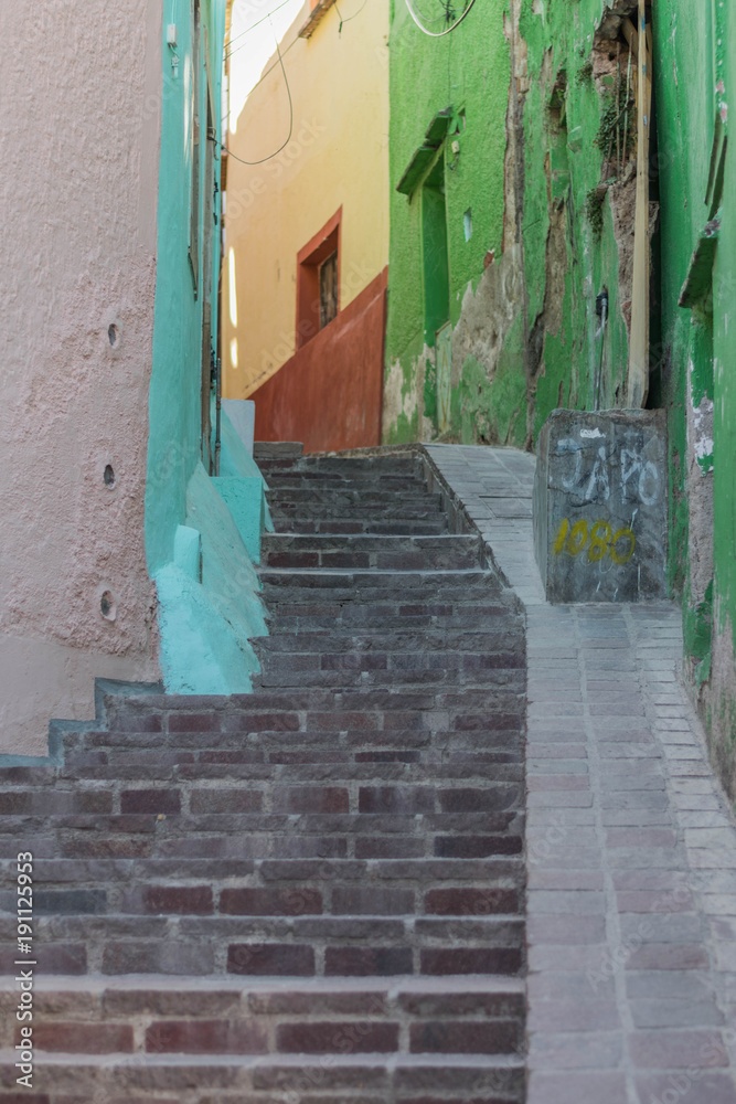 Steep brick steps leading up and through a very narrow passageway, with ...