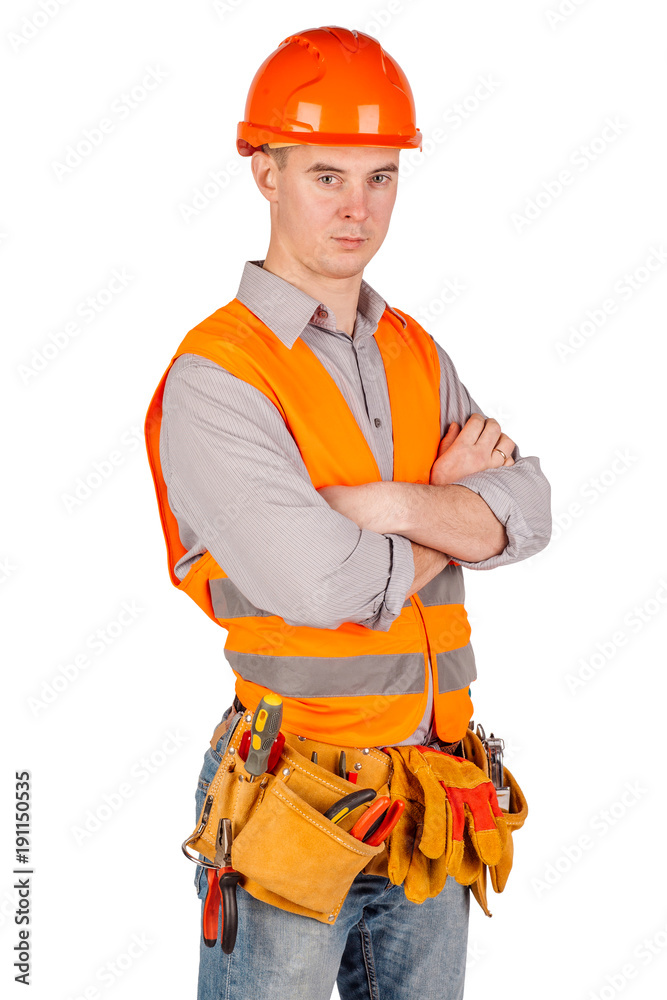 male builder in a helmet with crossed arms and looking at camera over ...