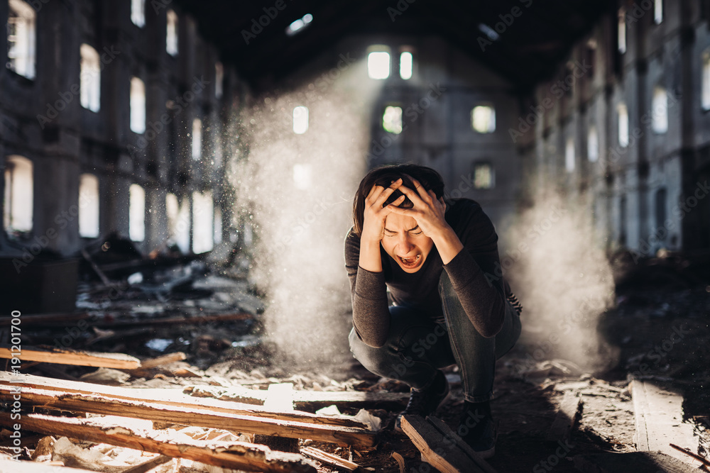 Sad depressed person in abandoned destroyed building crying.Emotional ...