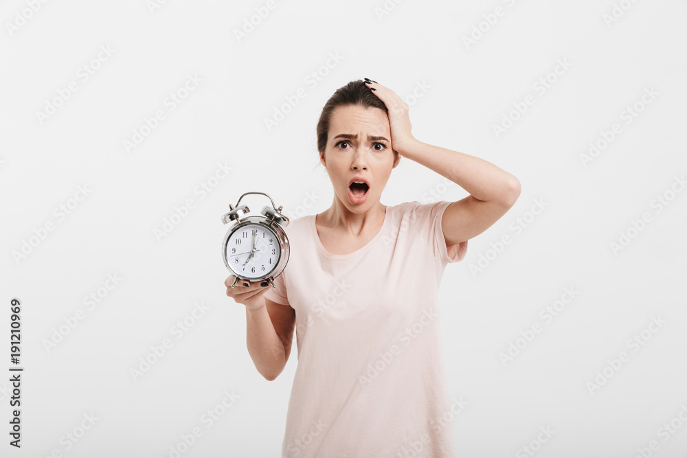 shocked girl with alarm clock touching head isolated on white Stock ...