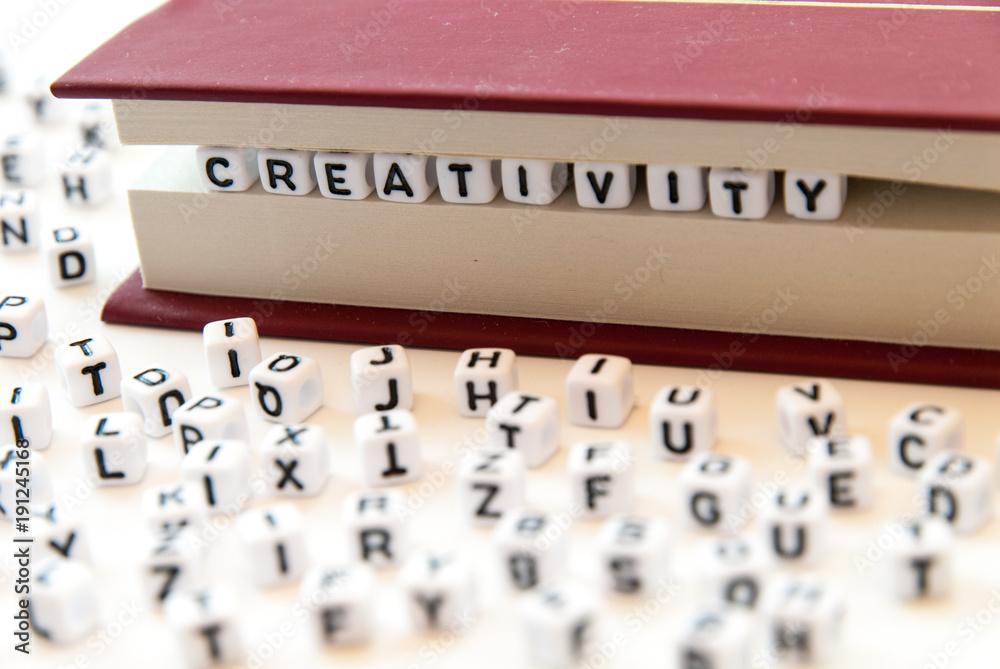 Word creativity written with letters between a book pages white ...