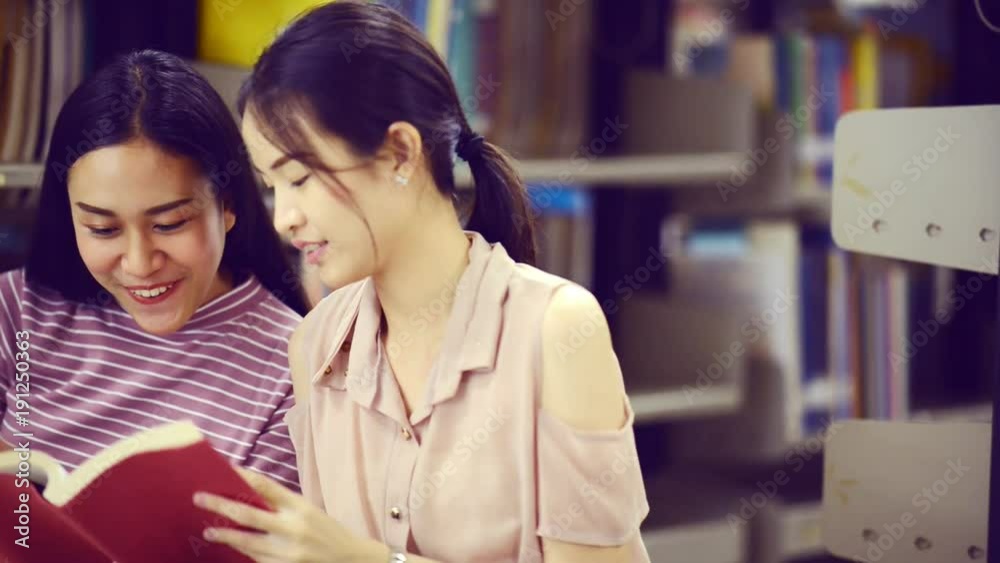 Students in library doing assignment. Attractive asian female student ...