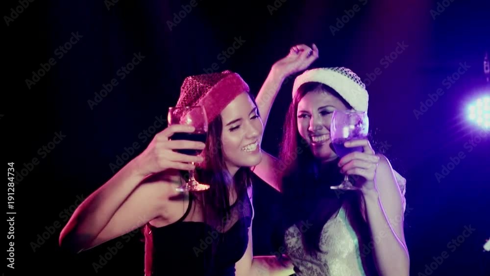 Drunk woman in night club. Group of attractive people having party in night club. Cheering and ...