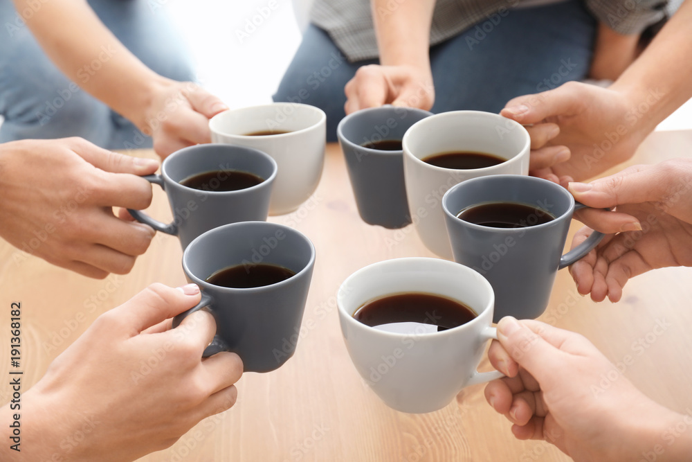 Foto de People putting cups of coffee together over wooden table. Unity ...