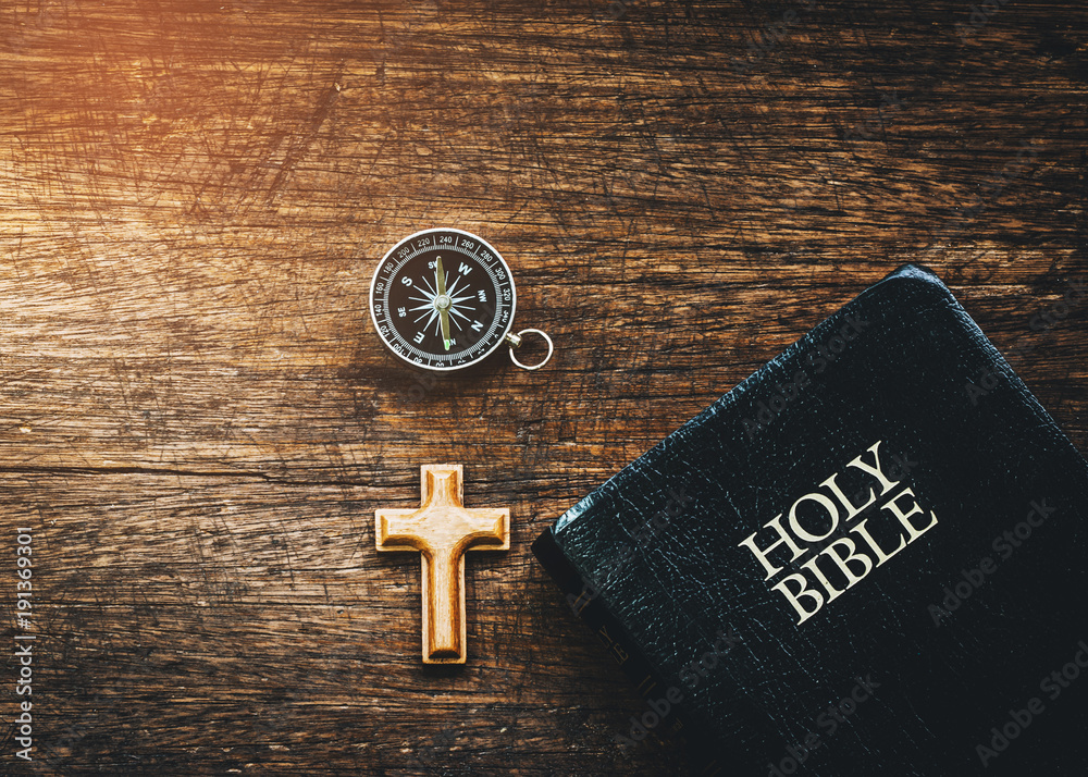 holy bible with small wooden cross and compass on dark wood background ...