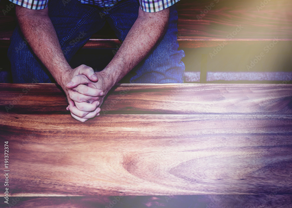 man hands praying on wooden table with window light effected, christian ...