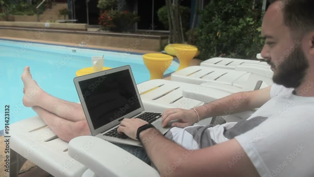 Portrait of male writer, who is writing a novel on his laptop near ...