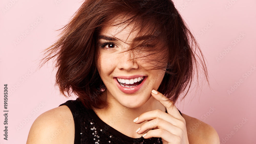 Beauty portrait of happy smiling female model with disheveled hair over ...