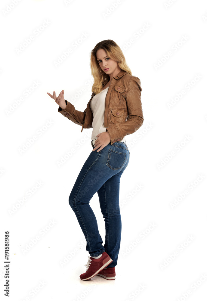 Full Length Portrait Of Blonde Girl Wearing Simple Brown Jacket And Jeans Standing Pose On