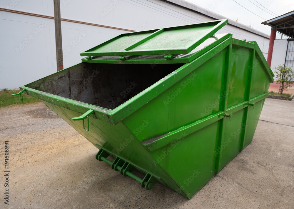 Big green dumpster garbage truck on the road in the factory, Side view ...