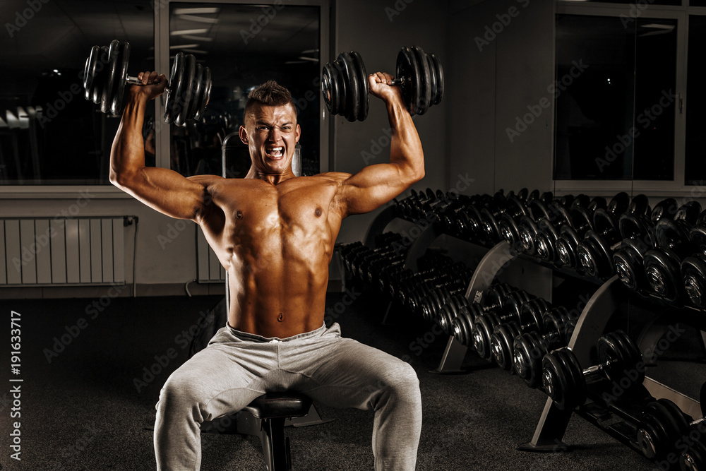 Photo & Art Print Brutal strong athletic men pumping up muscles and train in gym workout ...