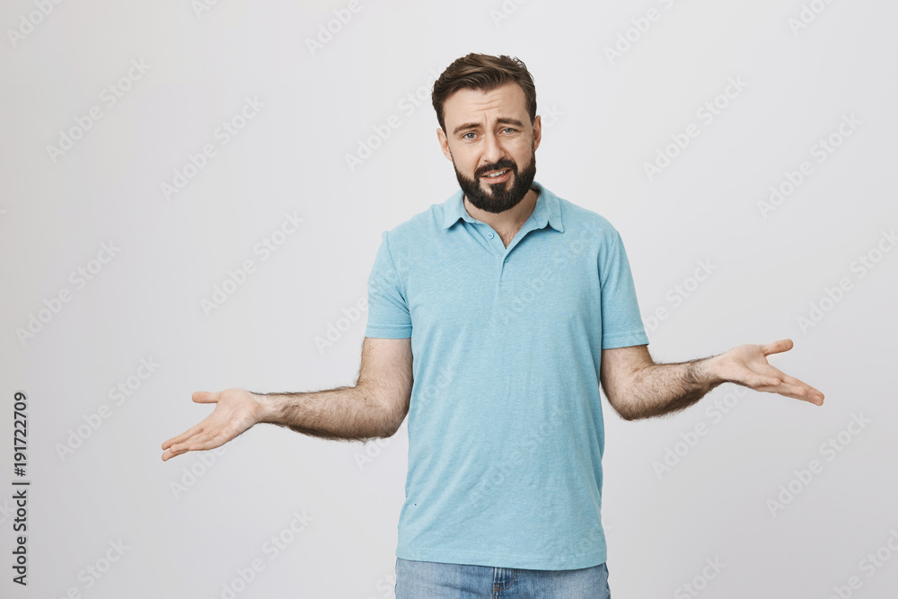 Picture of bearded handsome man looking questioned standing with spread ... Picture of bearded handsome man looking questioned standing with spread ...