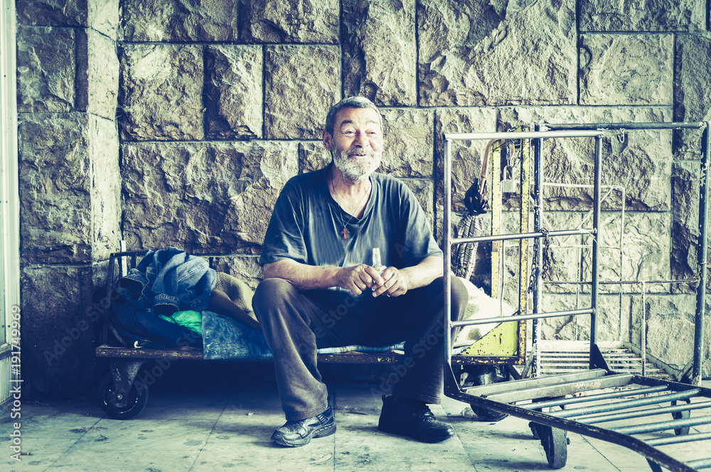 Happy and smiling poor homeless man sitting in the shadow of the ...