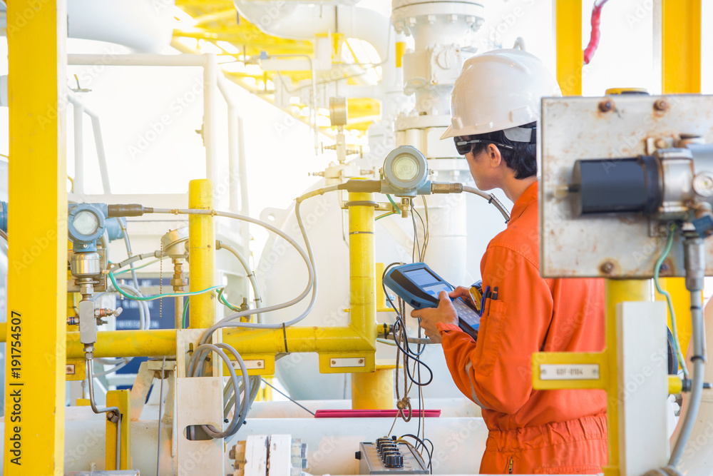 Fotka „Electrical and Instrument operator calibrating temperature and ...