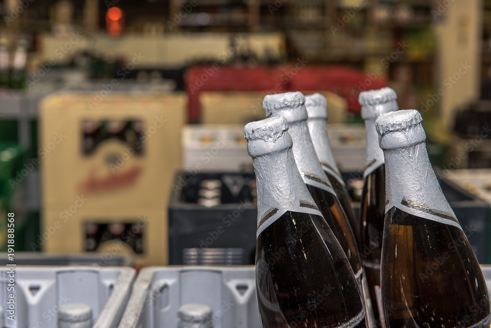 Beer bottles are stacked reusable containers are in a beverage market ...