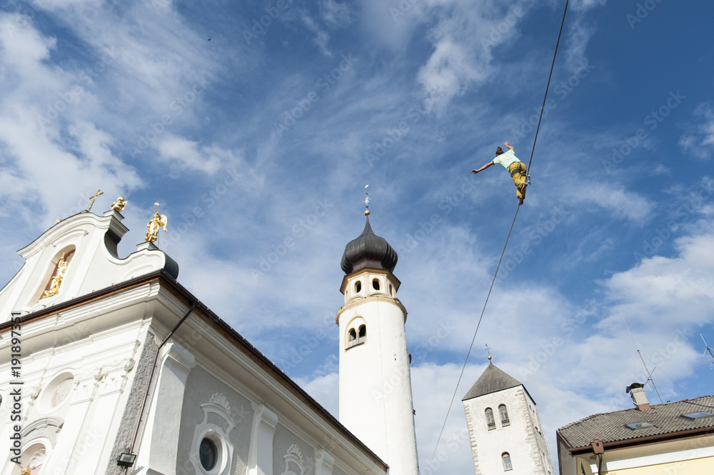 tightrope walker, man hanging on a rope walks in the sky between bell ...
