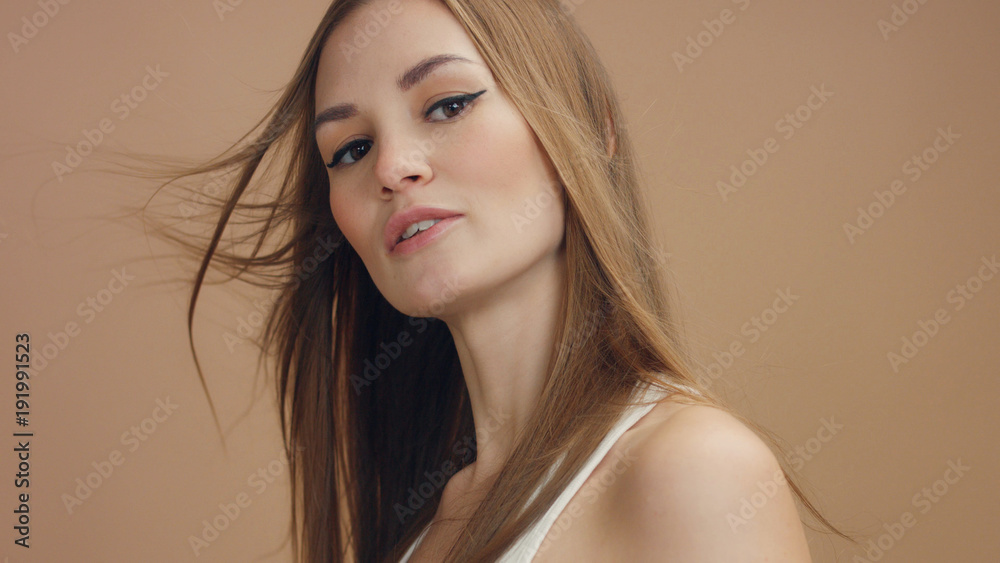 slowmotion closeup of model in studio with blowing hair turning and ...