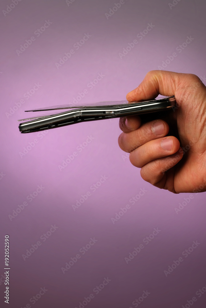 broken black mobile smartphone with a cracked display lying in his hand ...