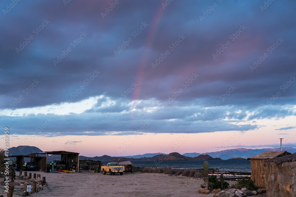 A rainbow over a homestead on the Baja California Peninsula. The sea of ...