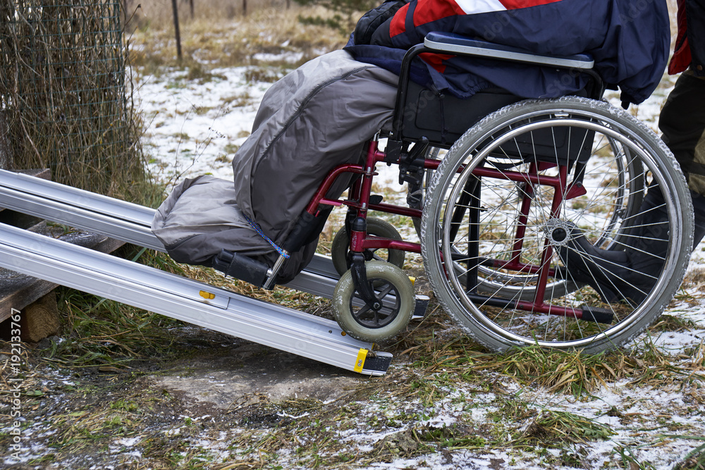 Rolling up a disabled person in wheelchair into a country house using ...