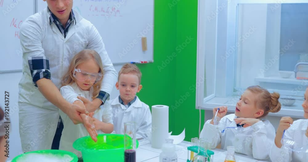 Teacher and students doing science experiment in school classroom ...
