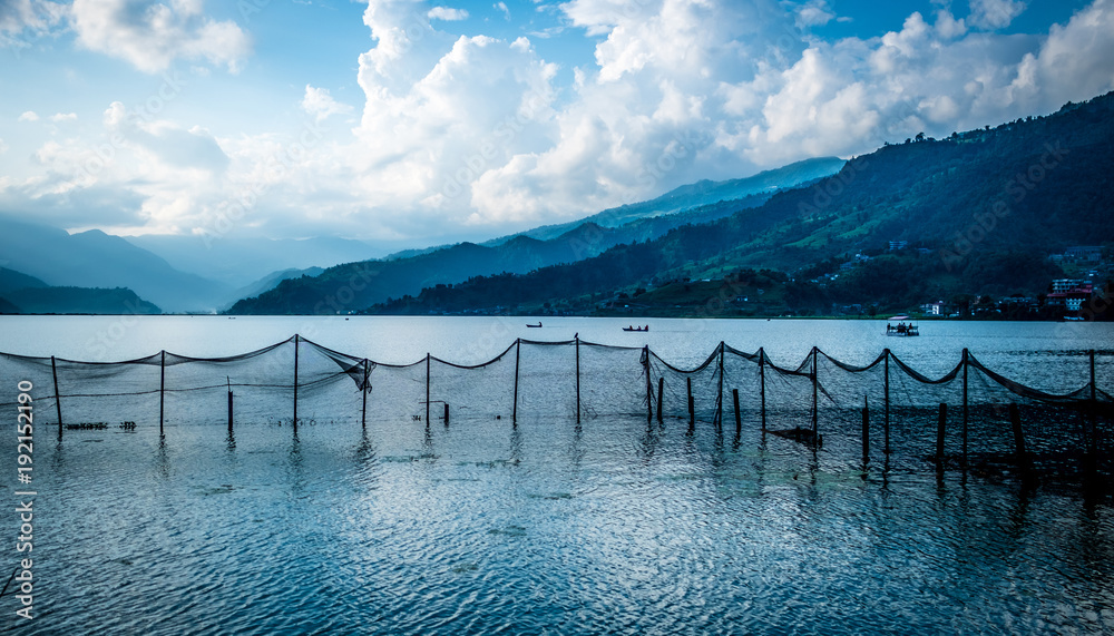 Fishing net pulled in a line on the Phewa lake, Pokhara. Beautiful view ...