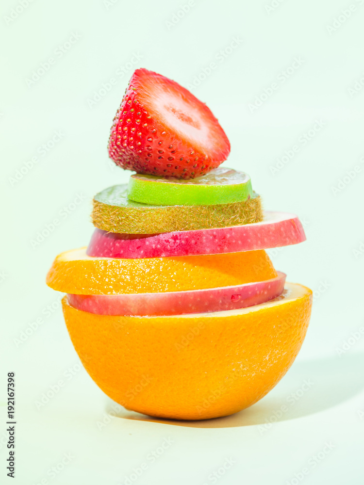 stack of different fruit slices on sofe green background, concept for ...