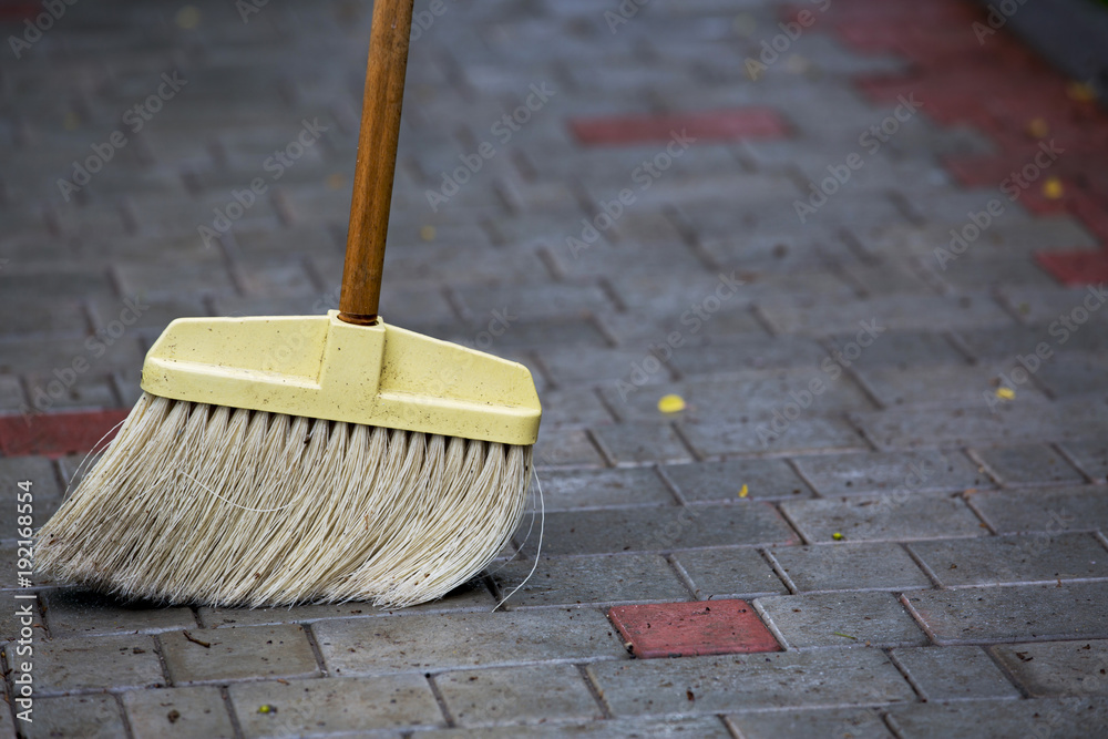 broom cleans paving slabs Stock Photo | Adobe Stock