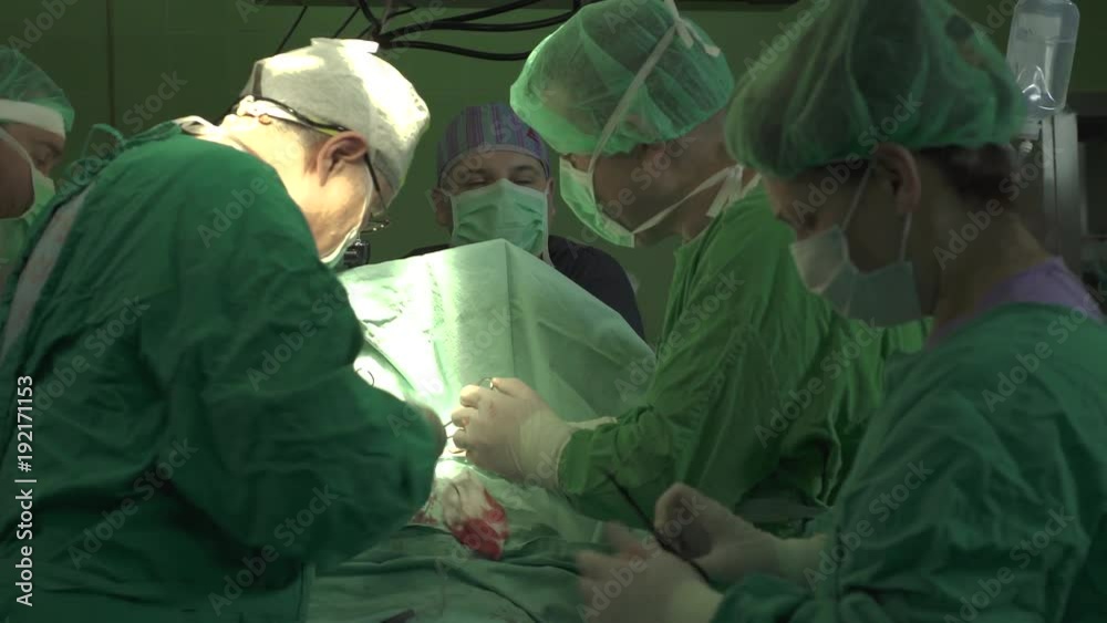 Surgical procedure,a team of male surgeons, anesthesiologist and female ...